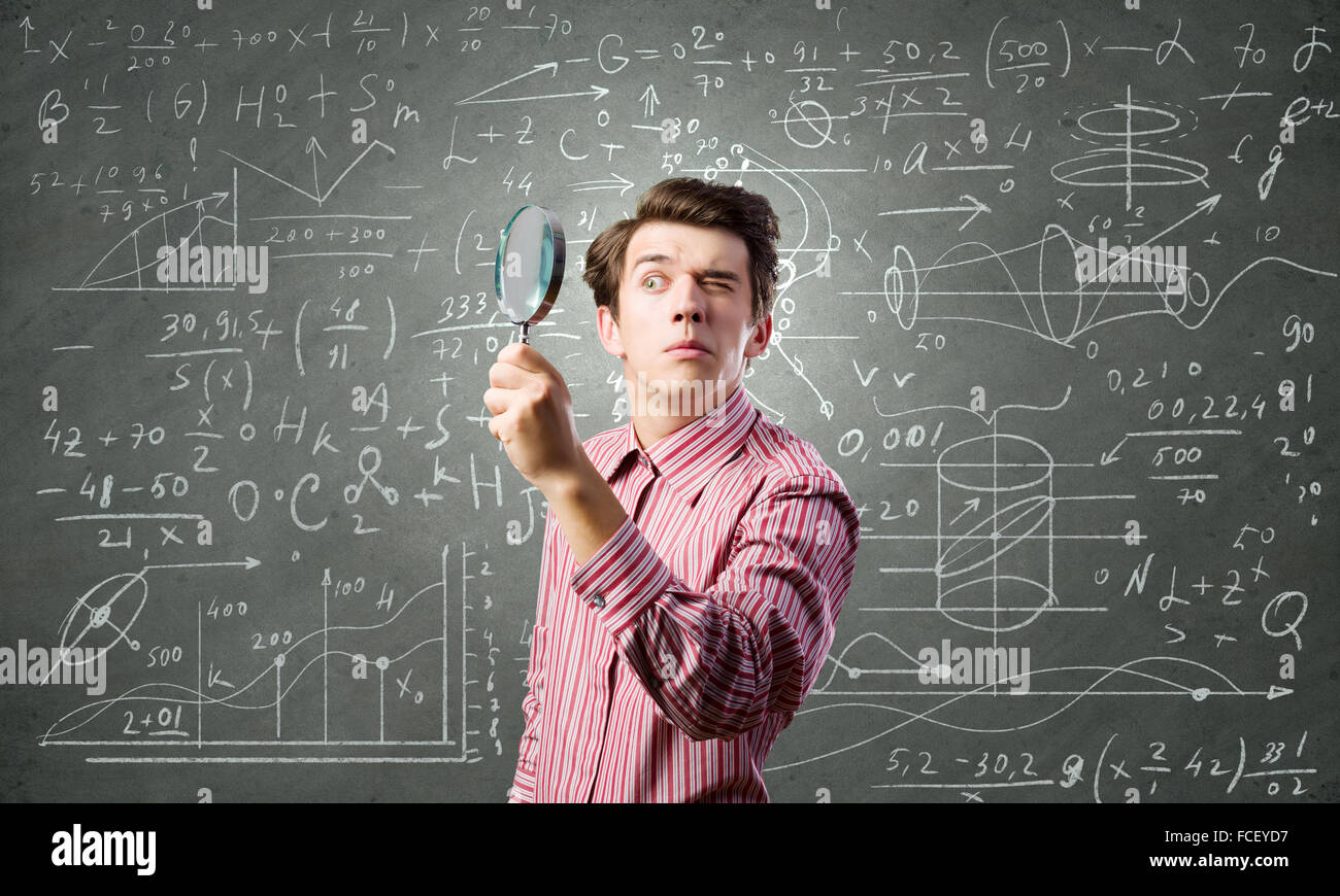 Young man scientist looking in magnifying glass Stock Photo - Alamy