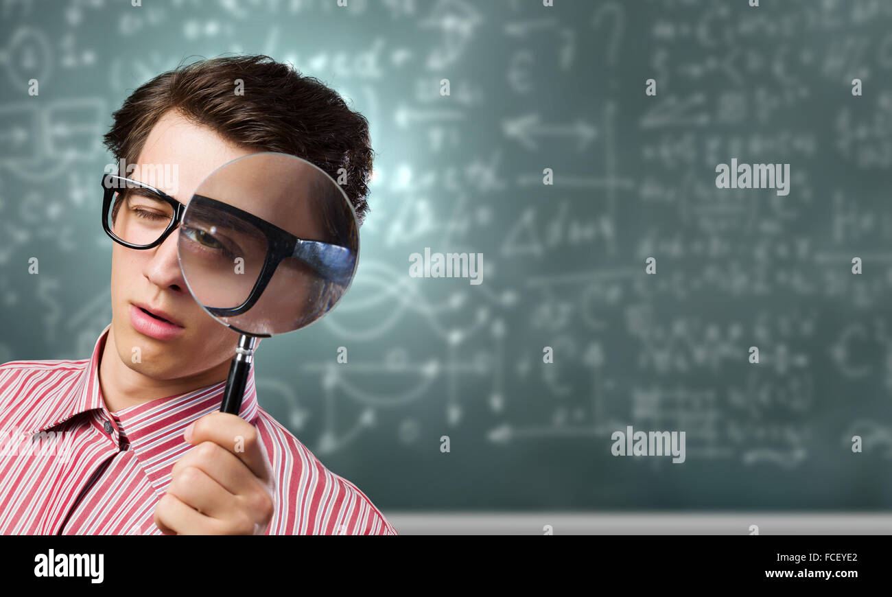 Young man scientist looking in magnifying glass Stock Photo - Alamy