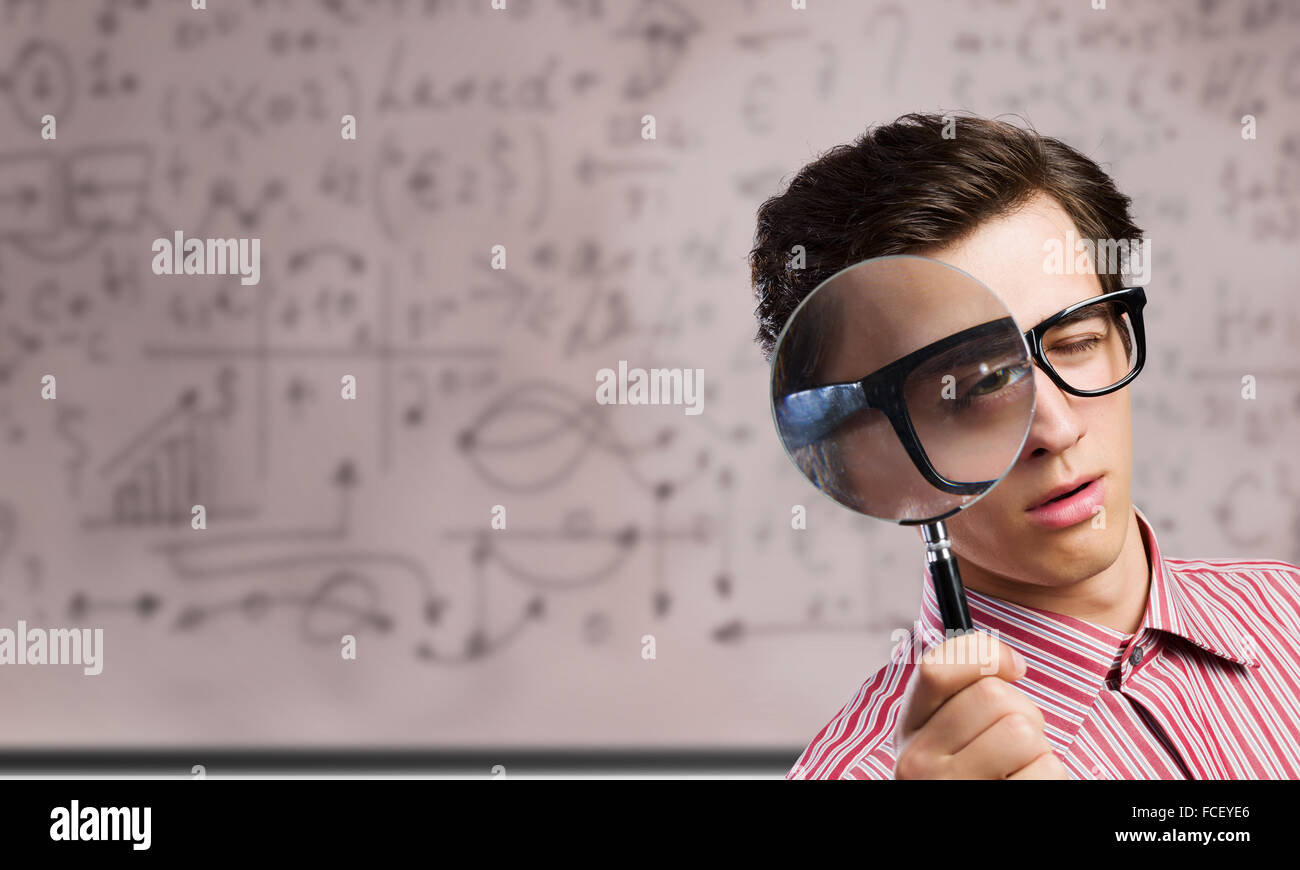 Young man scientist looking in magnifying glass Stock Photo - Alamy
