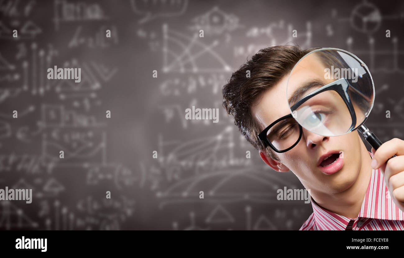 Young man scientist looking in magnifying glass Stock Photo - Alamy