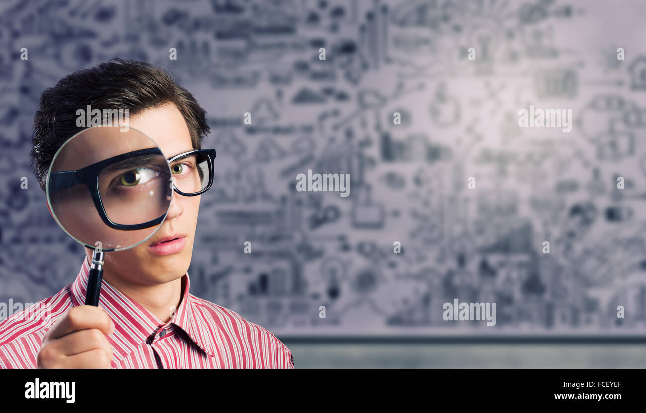 Young man scientist looking in magnifying glass Stock Photo - Alamy
