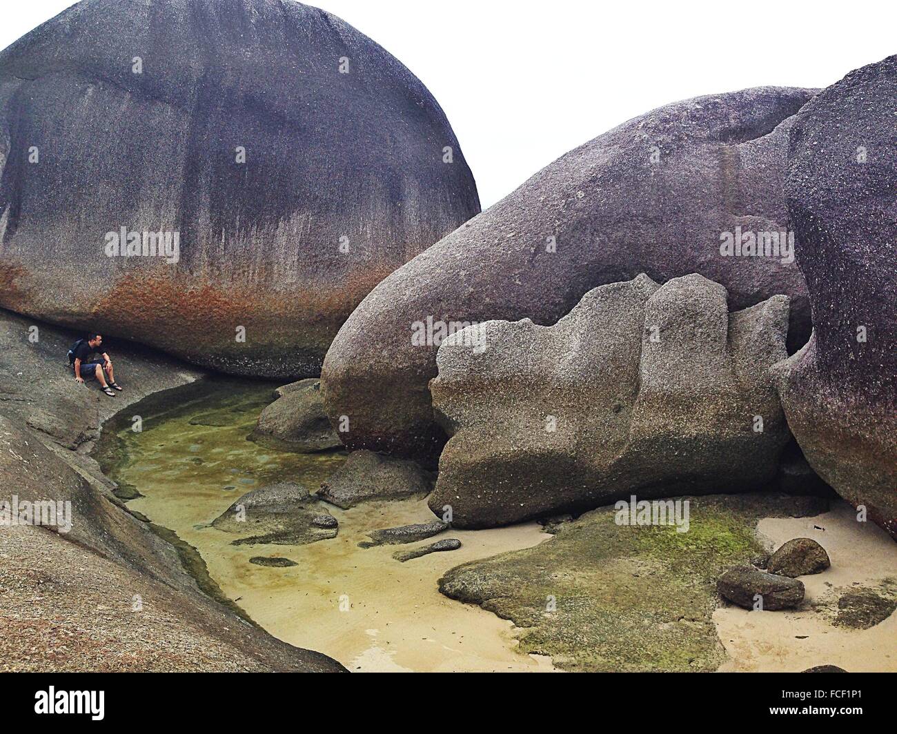 Man Sitting On Rocks Stock Photo - Alamy