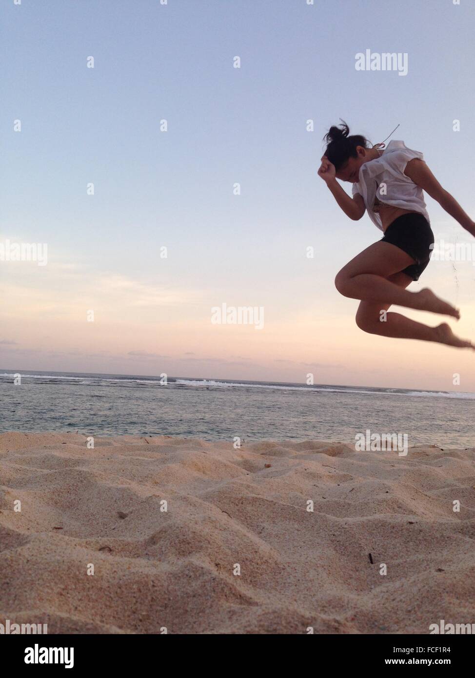 Woman Jumping On The Beach Stock Photo - Alamy
