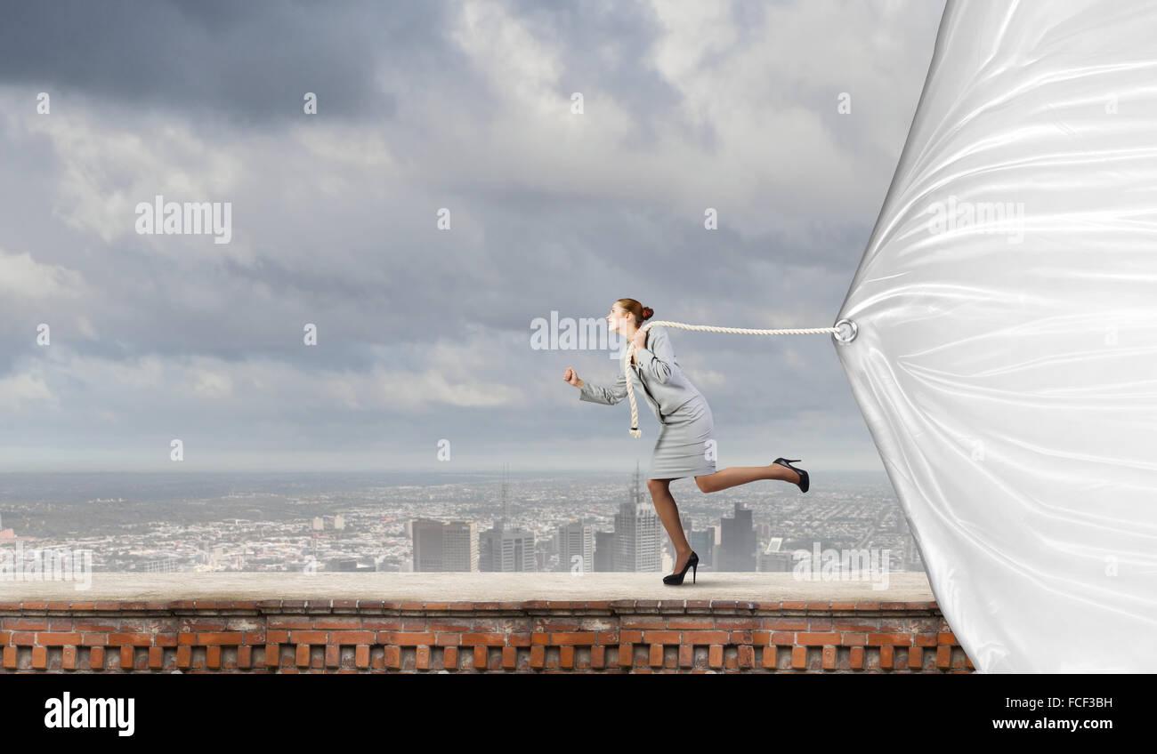 Young businesswoman running and pulling white blank banner Stock Photo ...