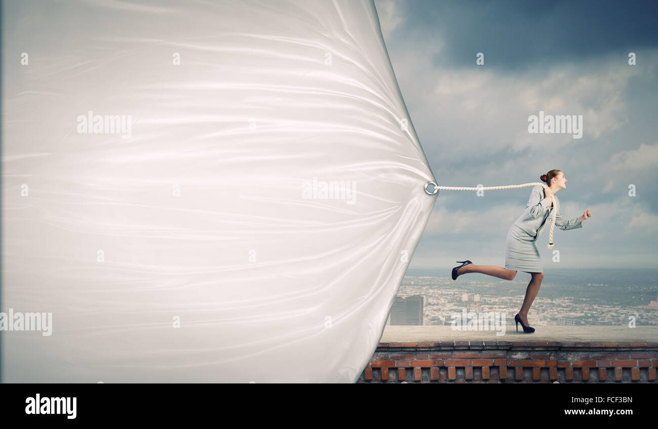 Young businesswoman running and pulling white blank banner Stock Photo ...