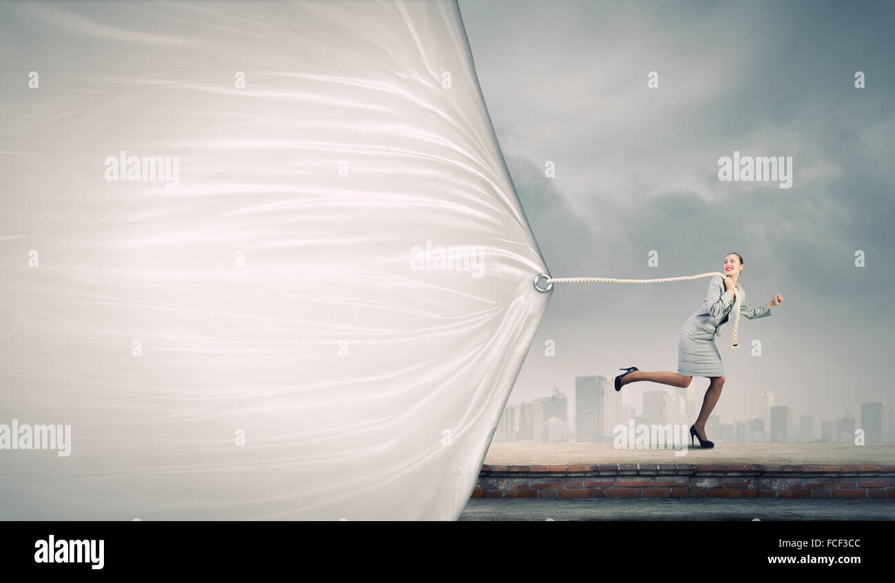Young businesswoman running and pulling white blank banner Stock Photo ...