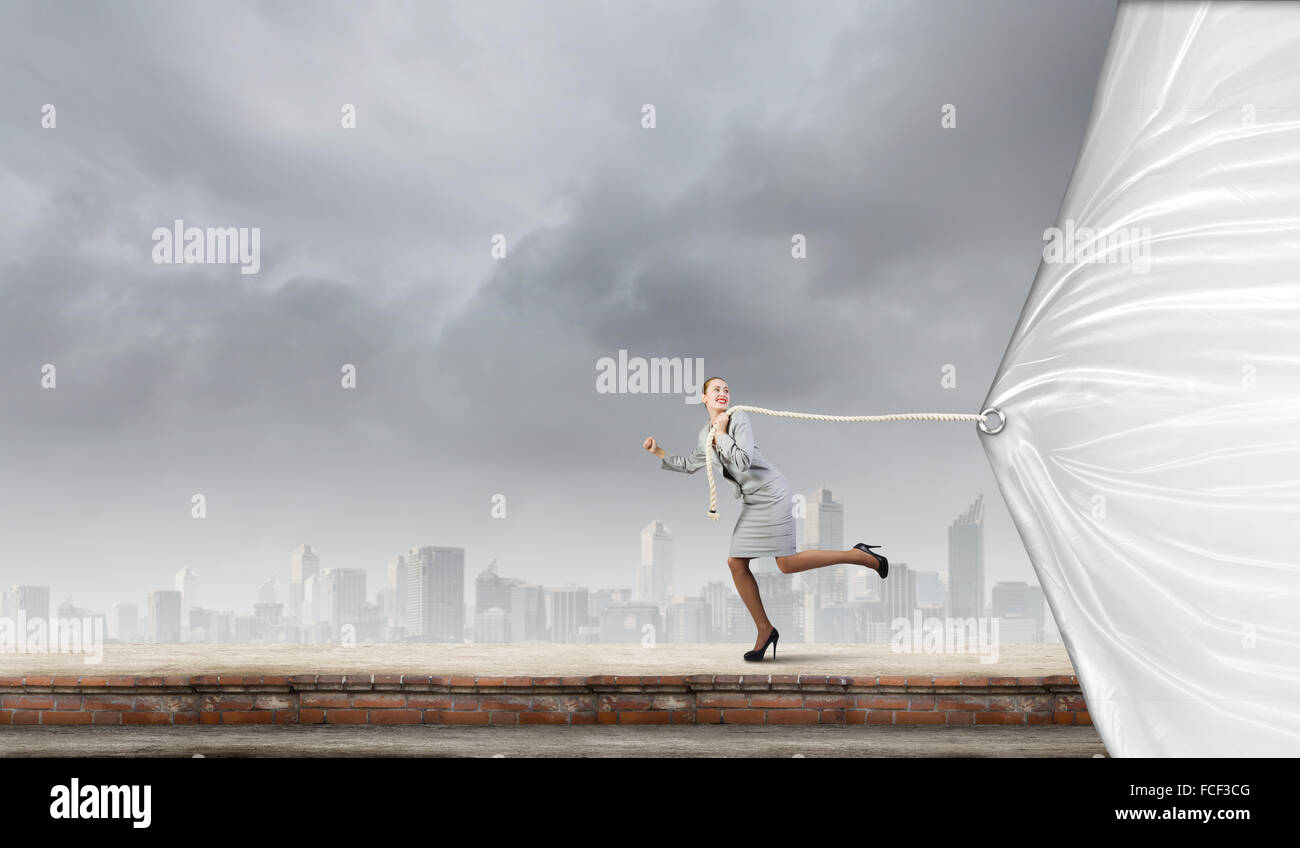 Young businesswoman running and pulling white blank banner Stock Photo ...