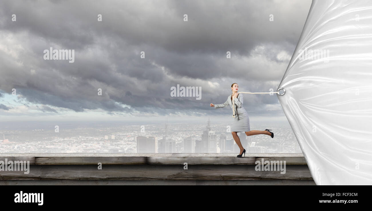 Young businesswoman running and pulling white blank banner Stock Photo ...