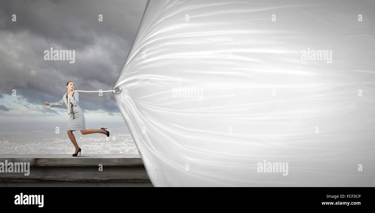 Young businesswoman running and pulling white blank banner Stock Photo ...