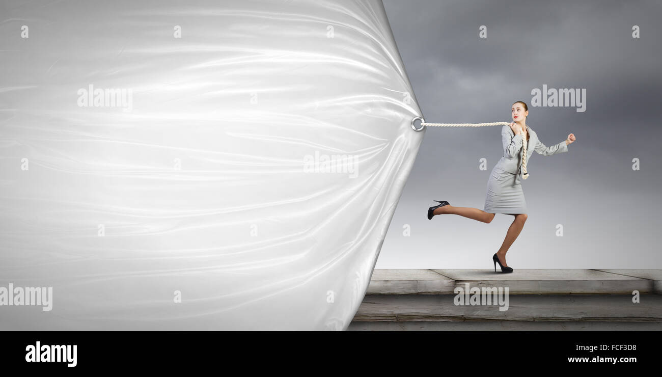 Young businesswoman running and pulling white blank banner Stock Photo ...