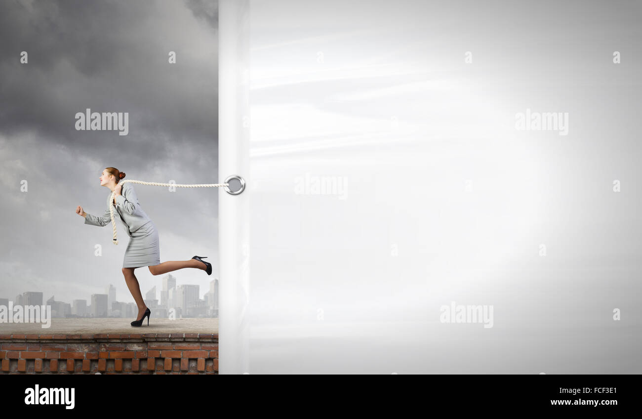 Young businesswoman running and pulling white blank banner Stock Photo ...