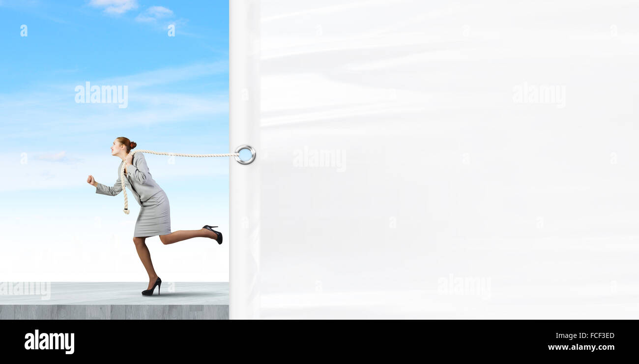 Young businesswoman running and pulling white blank banner Stock Photo ...