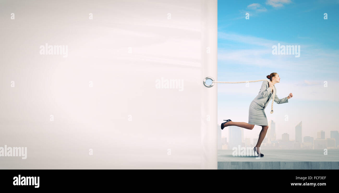 Young businesswoman running and pulling white blank banner Stock Photo ...