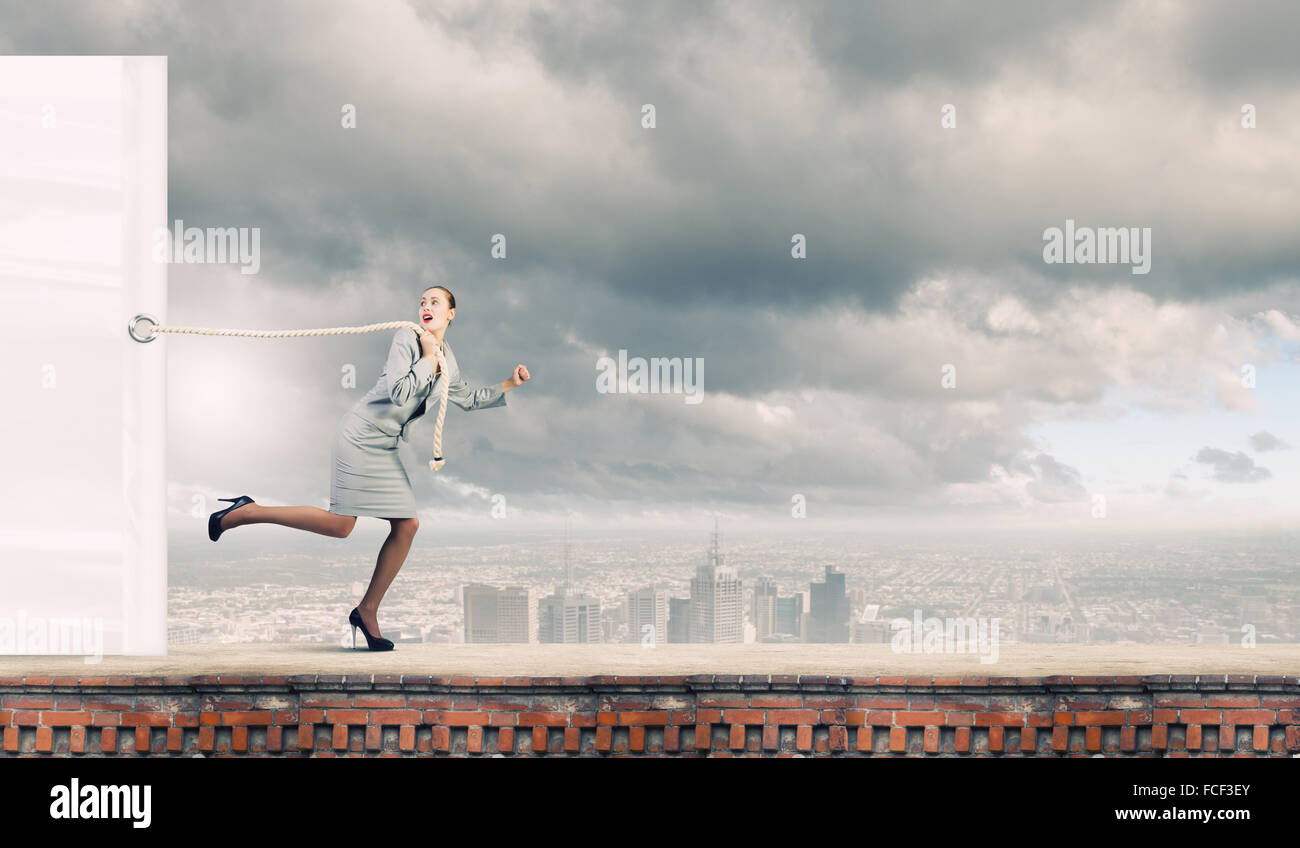 Young businesswoman running and pulling white blank banner Stock Photo ...