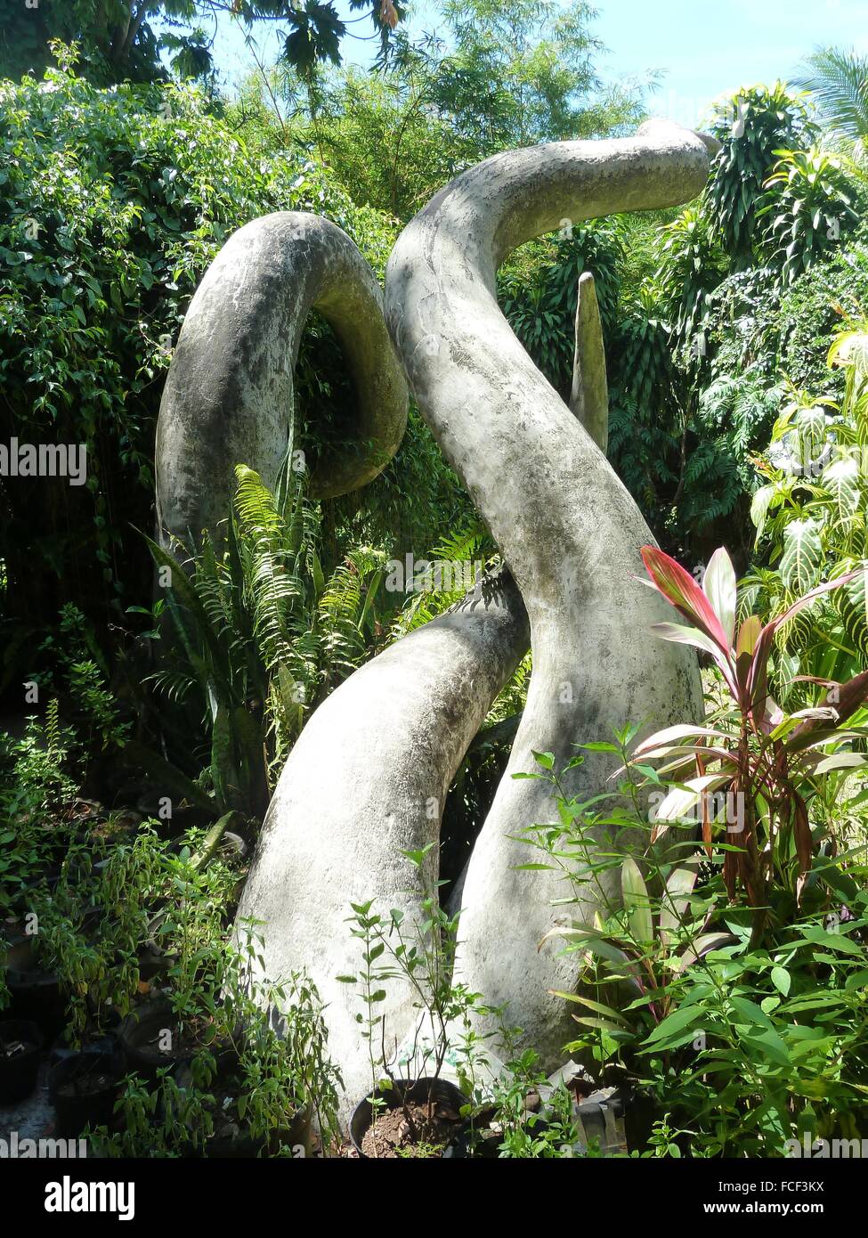 Plants Growing By Sculpture In Garden Stock Photo - Alamy