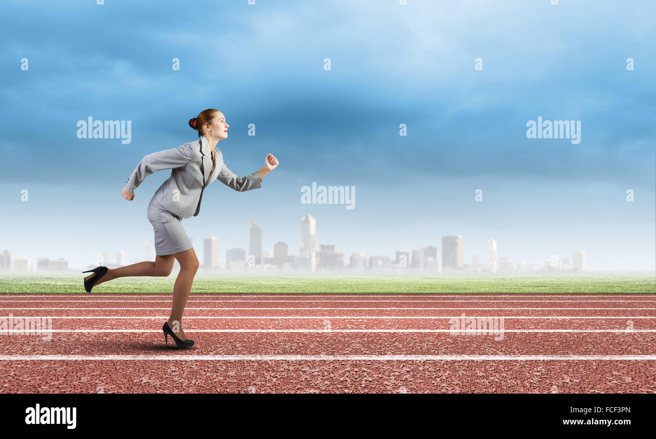 Young businesswoman in suit running on track Stock Photo - Alamy