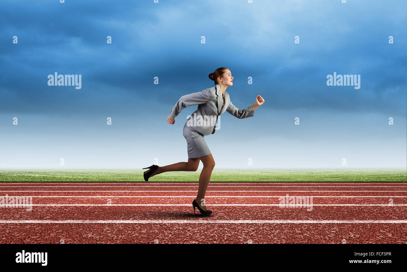 Young businesswoman in suit running on track Stock Photo - Alamy