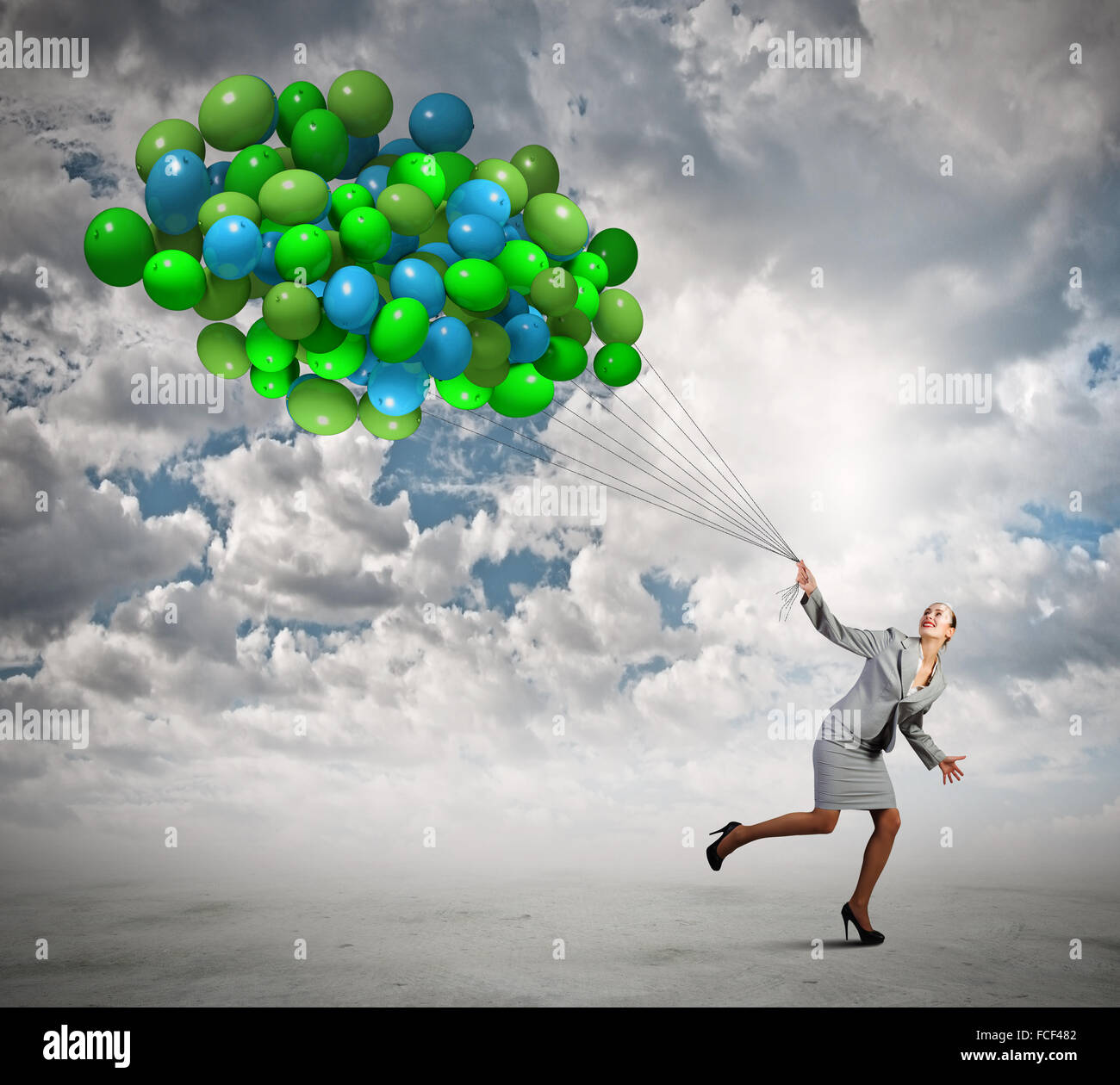 Young businesswoman running with bunch of colorful balloons Stock Photo ...