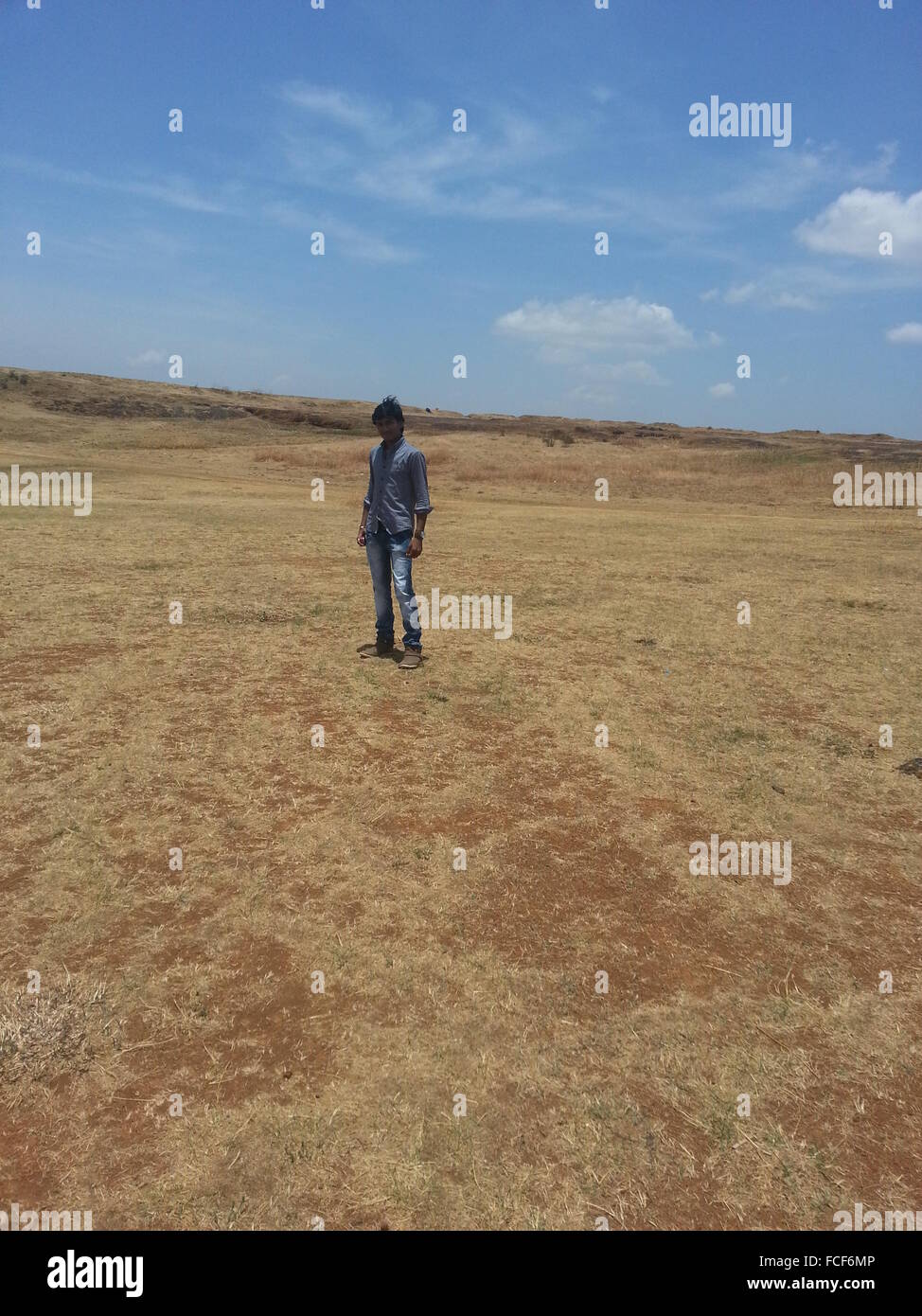 Full Length Of Young Man Standing In Field Stock Photo - Alamy
