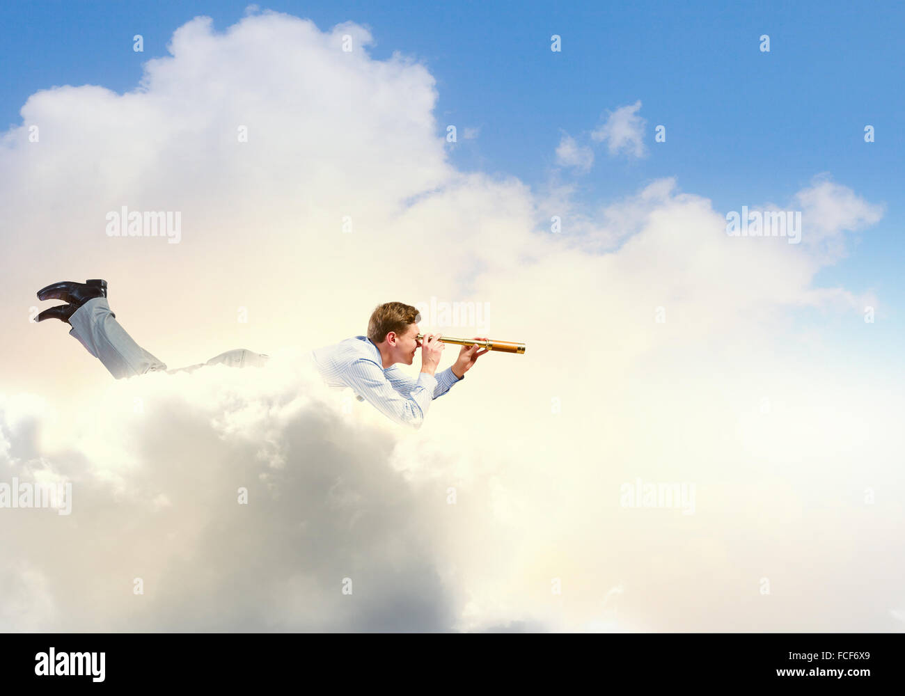 Young man flying high in sky and looking in spyglass Stock Photo - Alamy