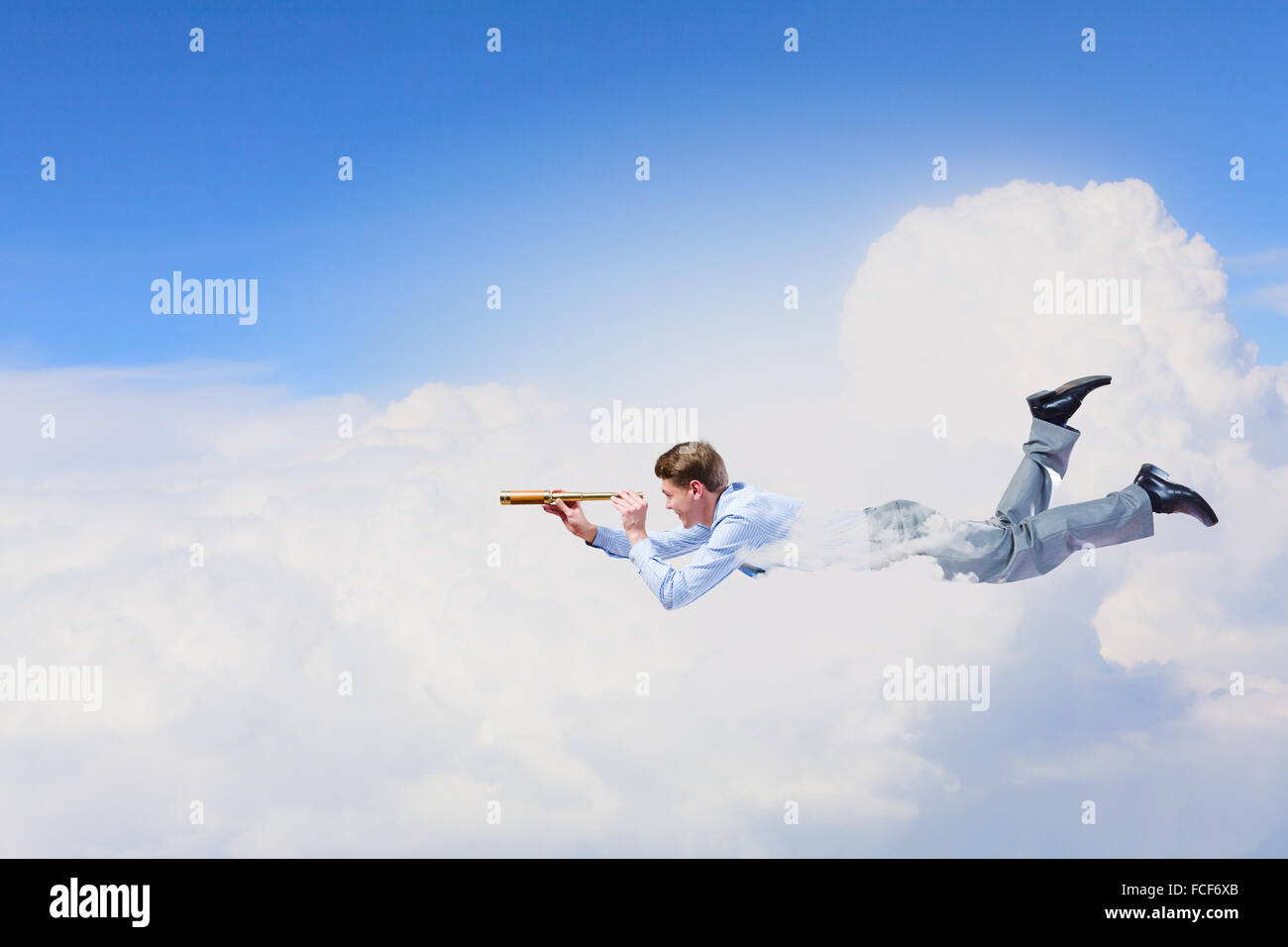 Young man flying high in sky and looking in spyglass Stock Photo - Alamy