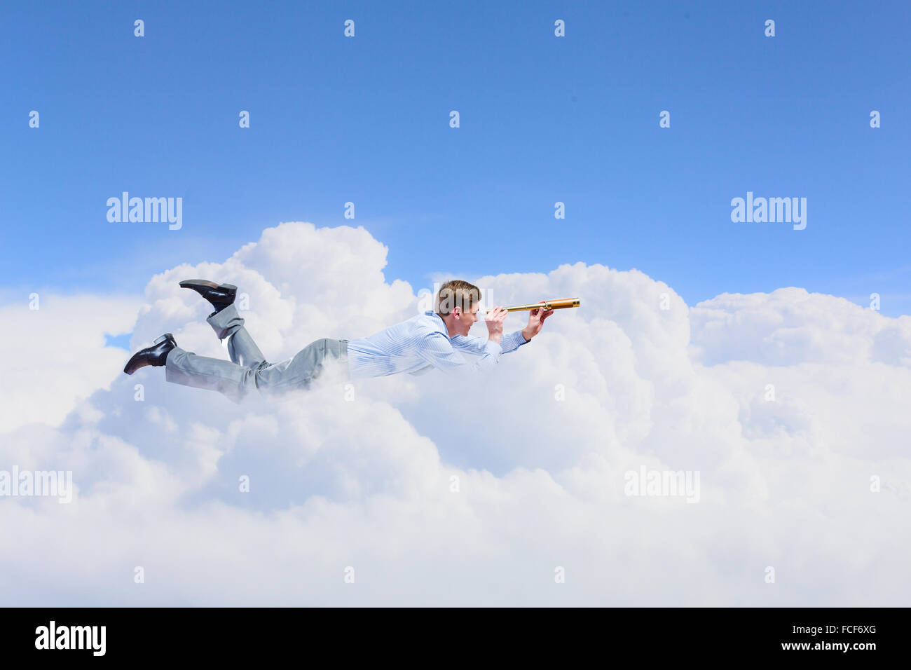 Young man flying high in sky and looking in spyglass Stock Photo - Alamy
