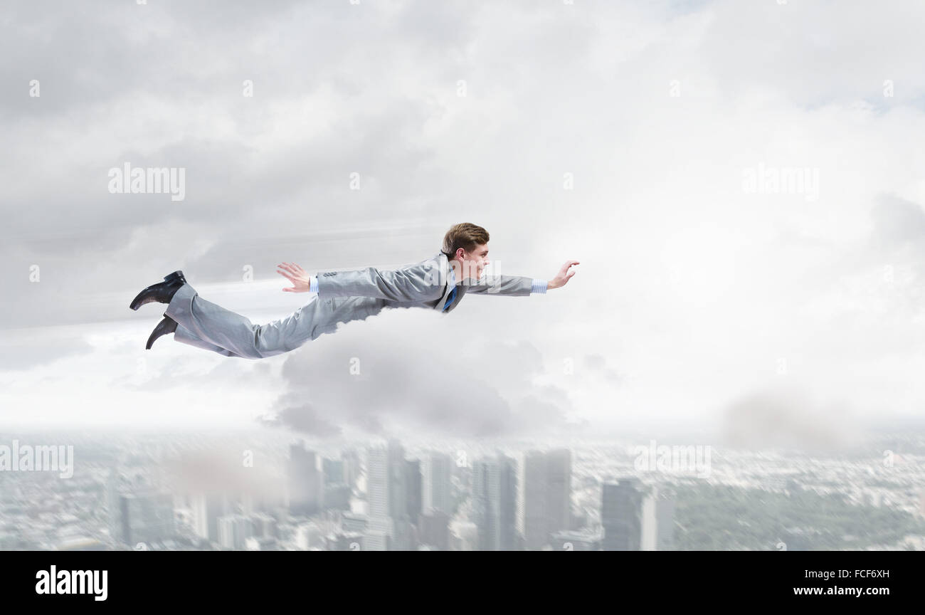 Young businessman superhero flying high in sky Stock Photo - Alamy