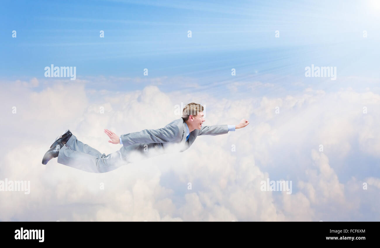 Young businessman superhero flying high in sky Stock Photo - Alamy