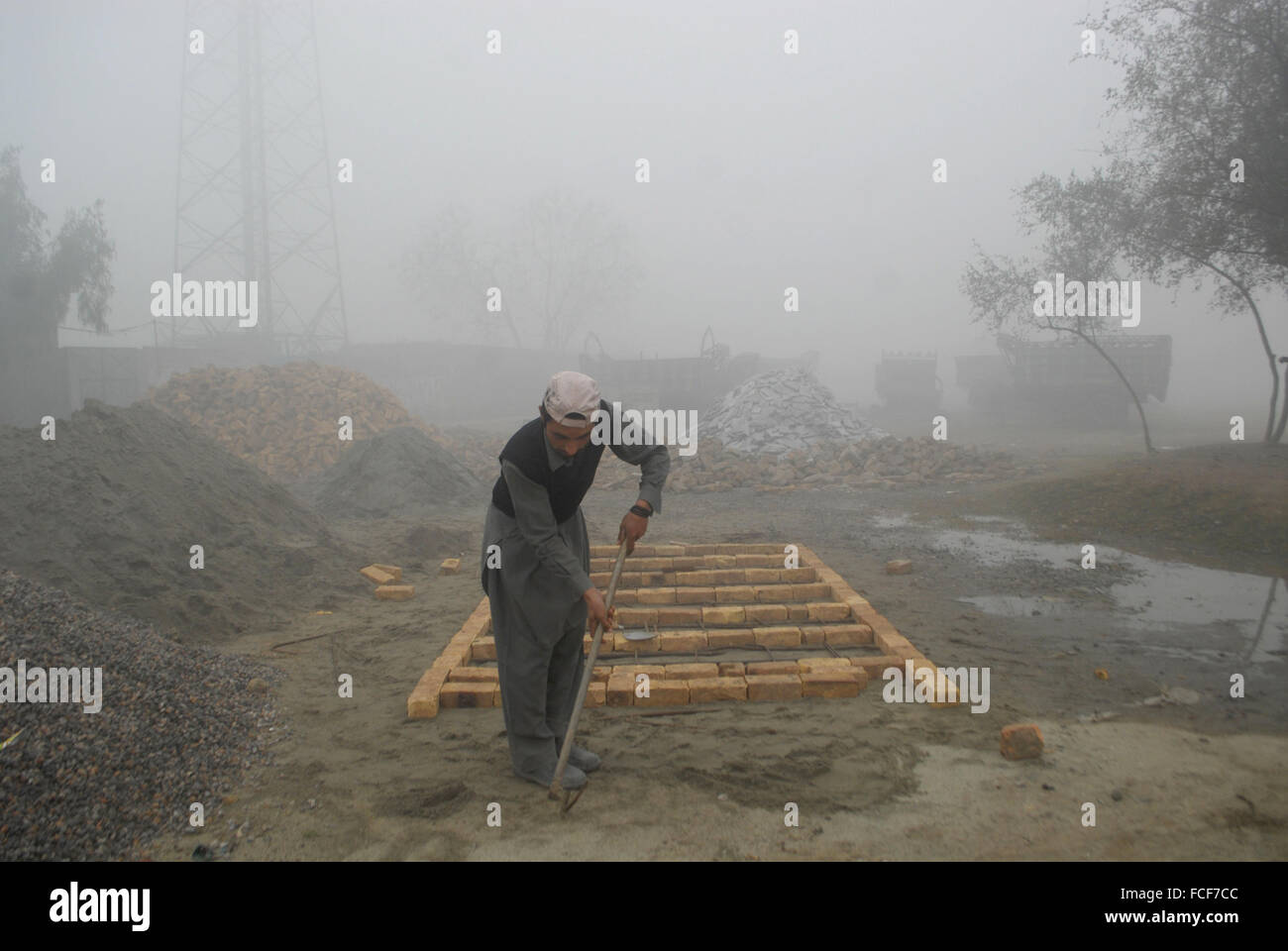 Peshawar. 22nd Jan, 2016. A laborer works during dense fog in northwest ...
