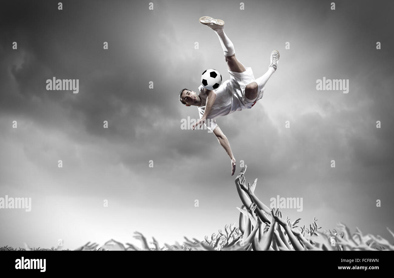 Football player in jump kicking the ball supported by fans Stock Photo ...