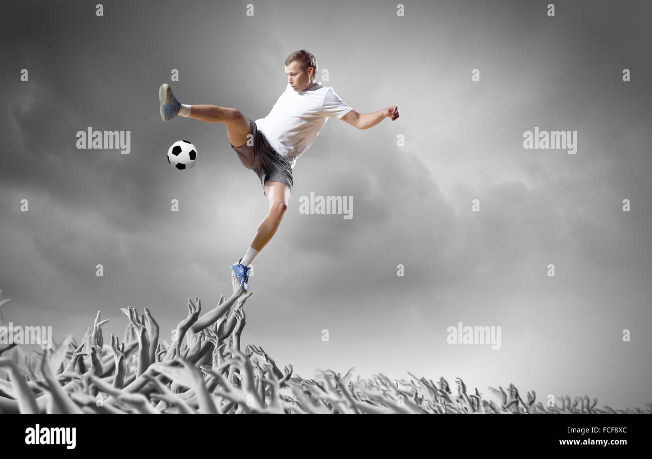 Football player in jump kicking the ball supported by fans Stock Photo ...