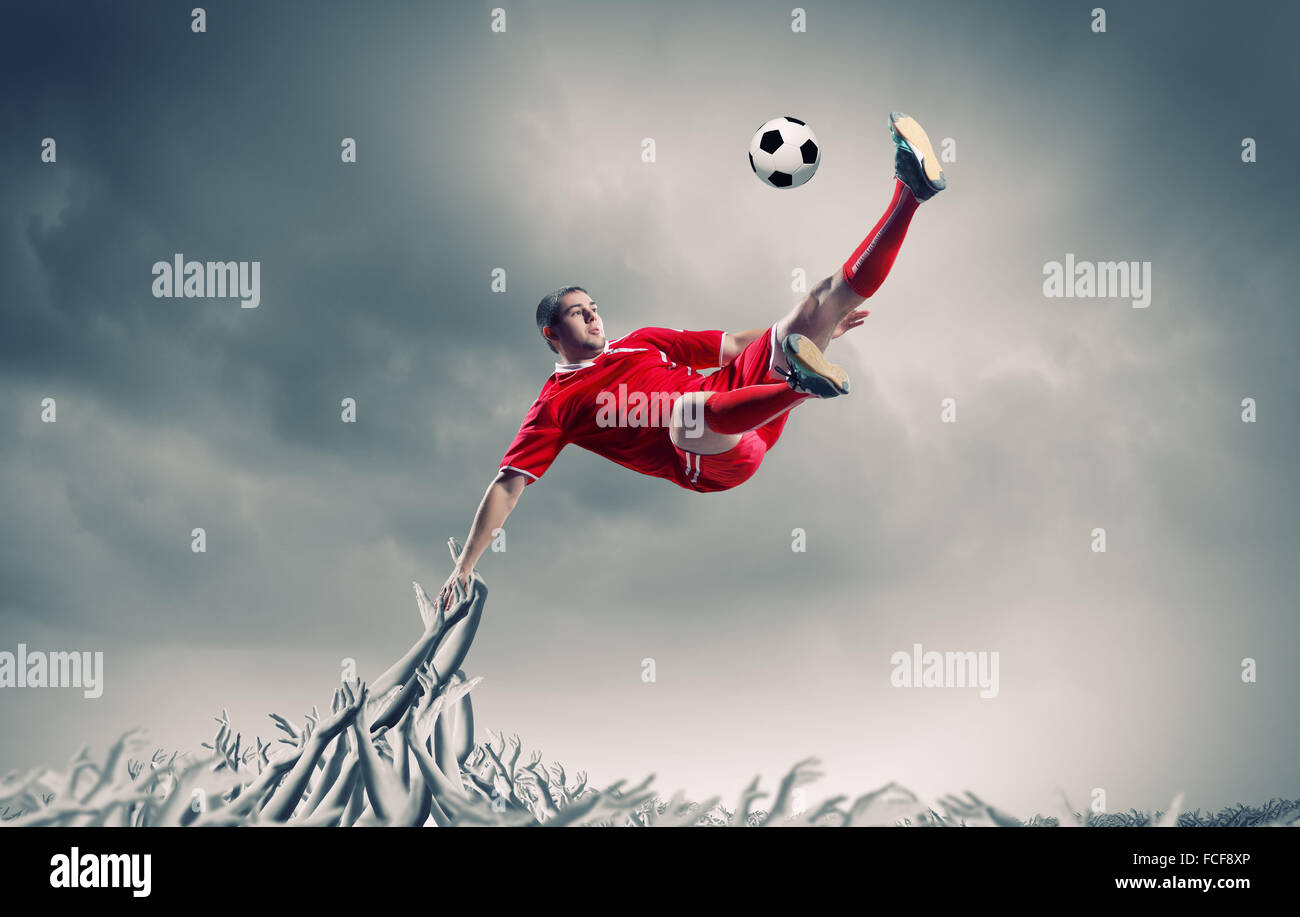 Football player in jump kicking the ball supported by fans Stock Photo ...