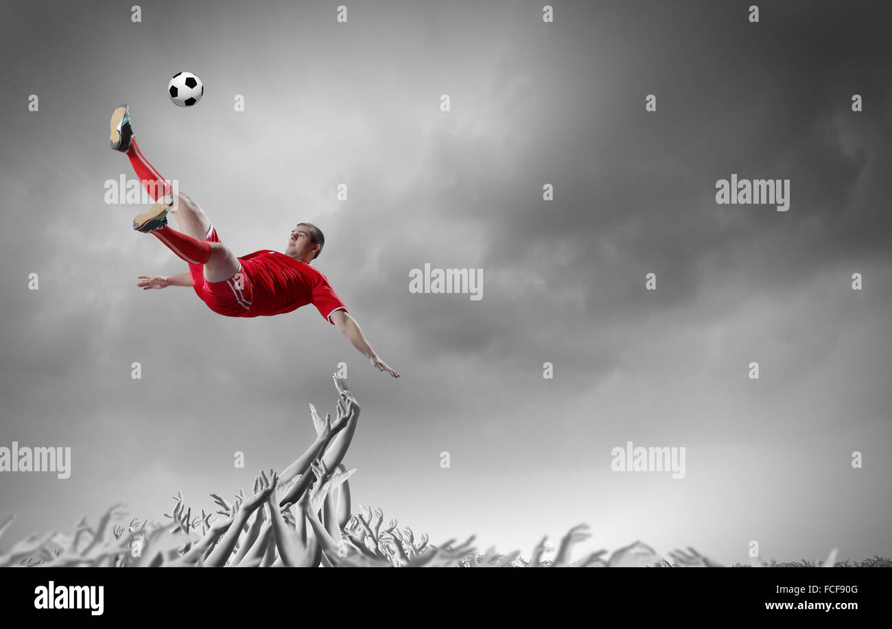 Football player in jump kicking the ball supported by fans Stock Photo ...