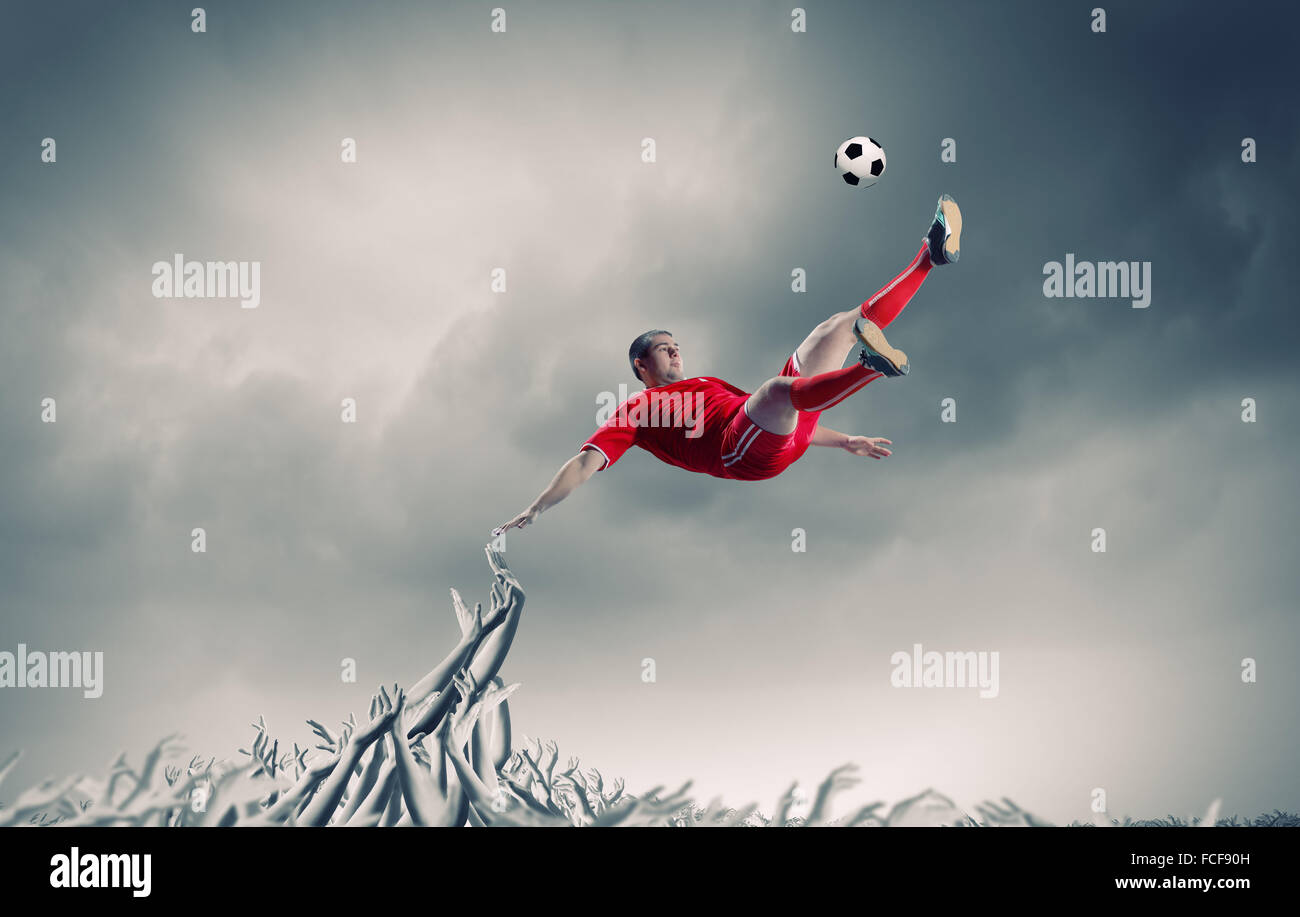 Football player in jump kicking the ball supported by fans Stock Photo ...