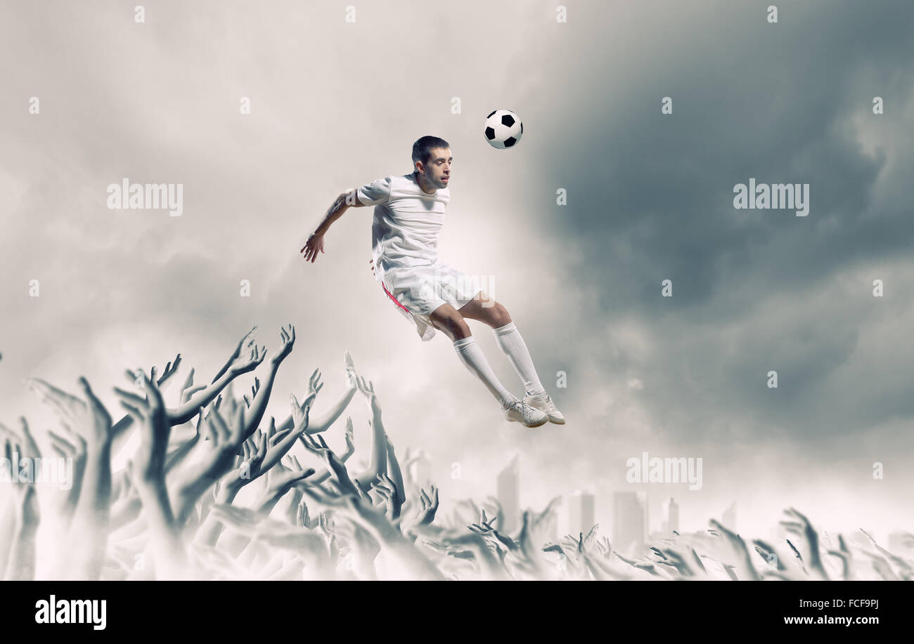 Football player in jump kicking the ball supported by fans Stock Photo ...