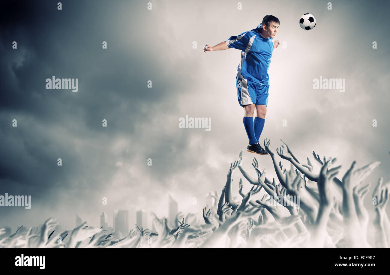 Football player in jump kicking the ball supported by fans Stock Photo ...