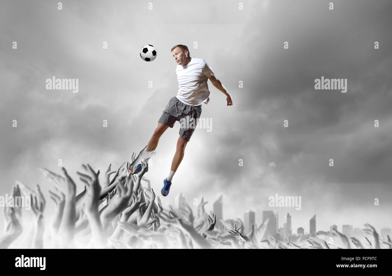 Football player in jump kicking the ball supported by fans Stock Photo ...