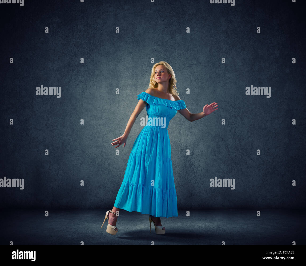 Anxious young woman in blue dress looking back worried Stock Photo - Alamy