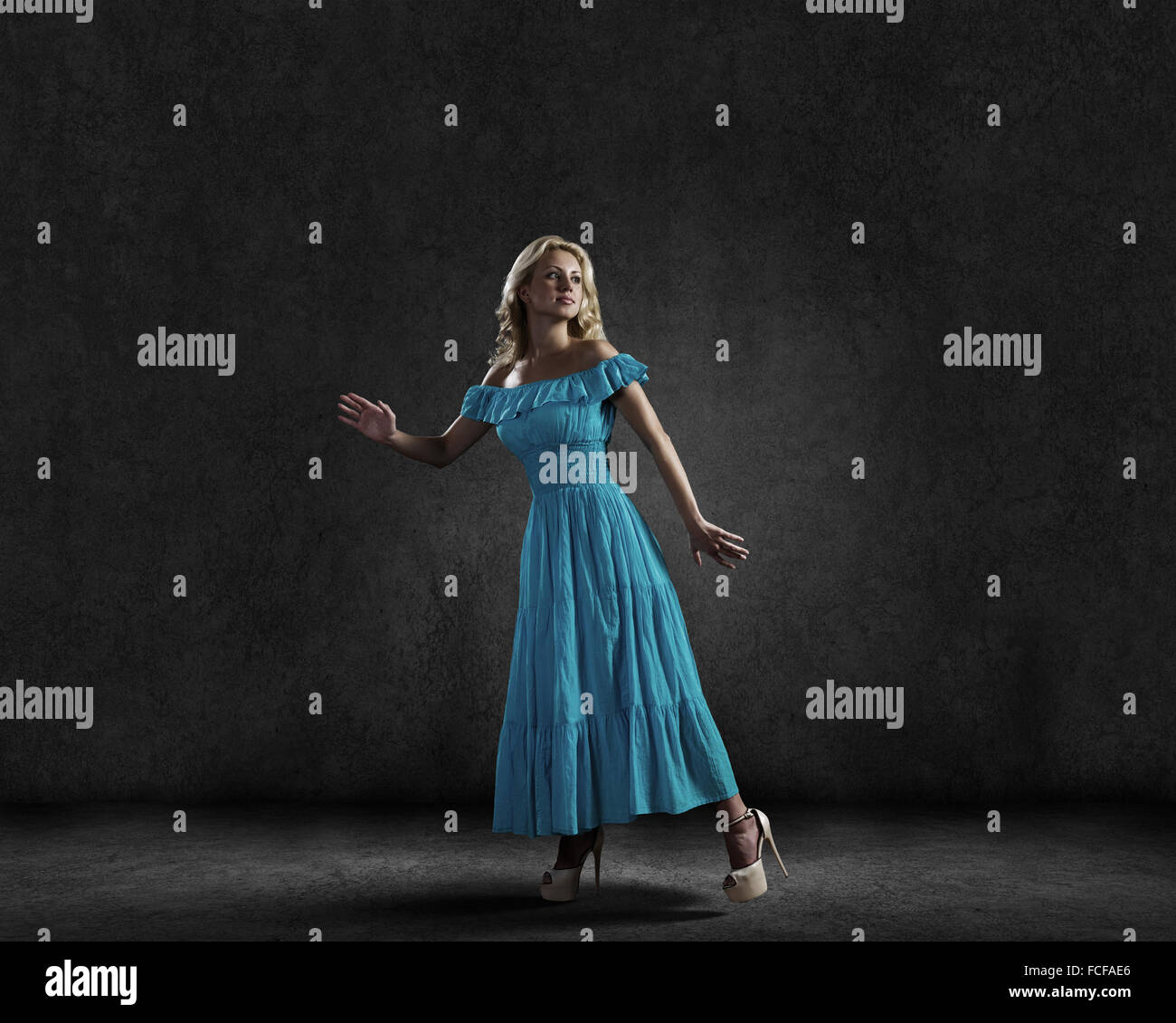 Anxious young woman in blue dress looking back worried Stock Photo - Alamy