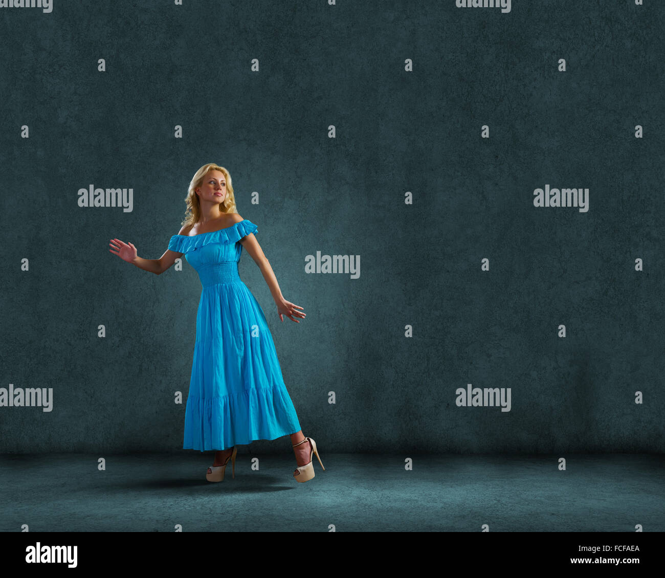 Anxious young woman in blue dress looking back worried Stock Photo - Alamy