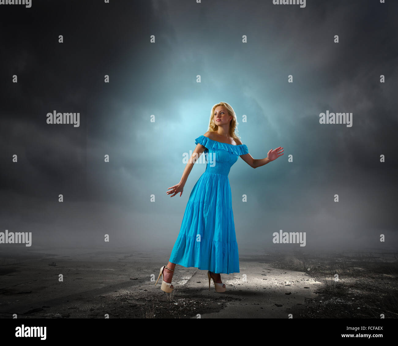 Anxious young woman in blue dress looking back worried Stock Photo - Alamy