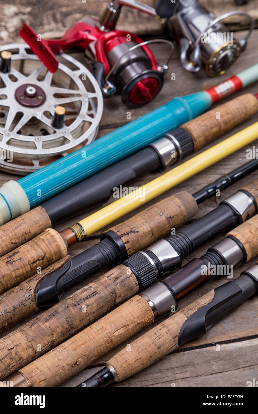 different fishing rods and reels on wooden boards background. creative ...