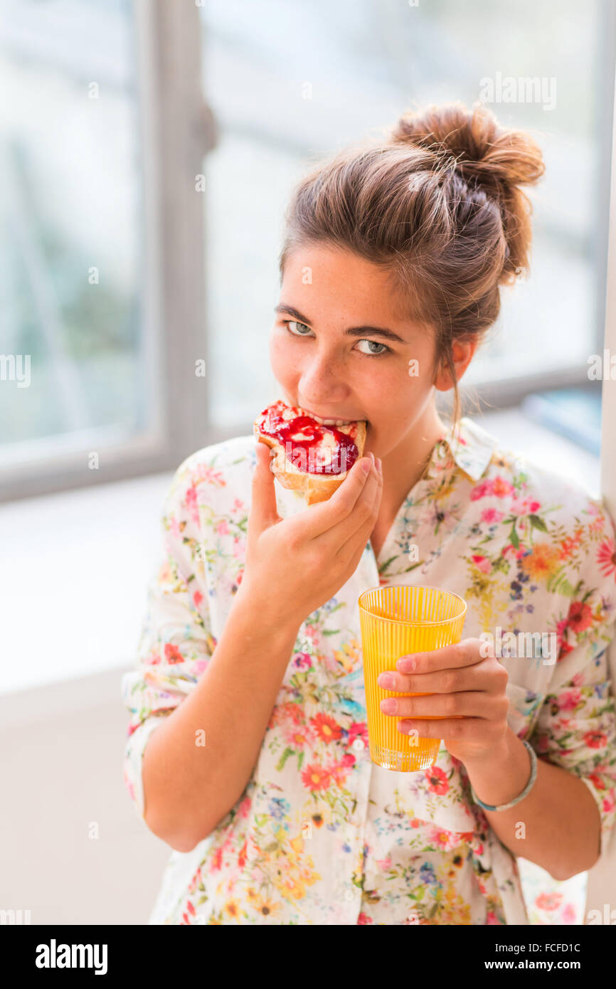 Woman eating a jam sandwich Stock Photo - Alamy