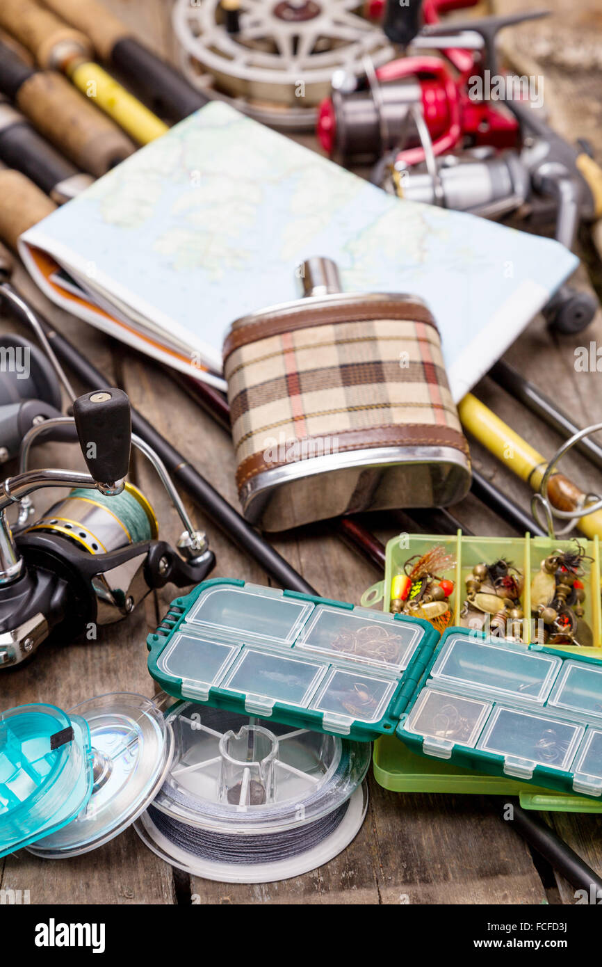 different fishing rods and reels on wooden boards background Stock ...