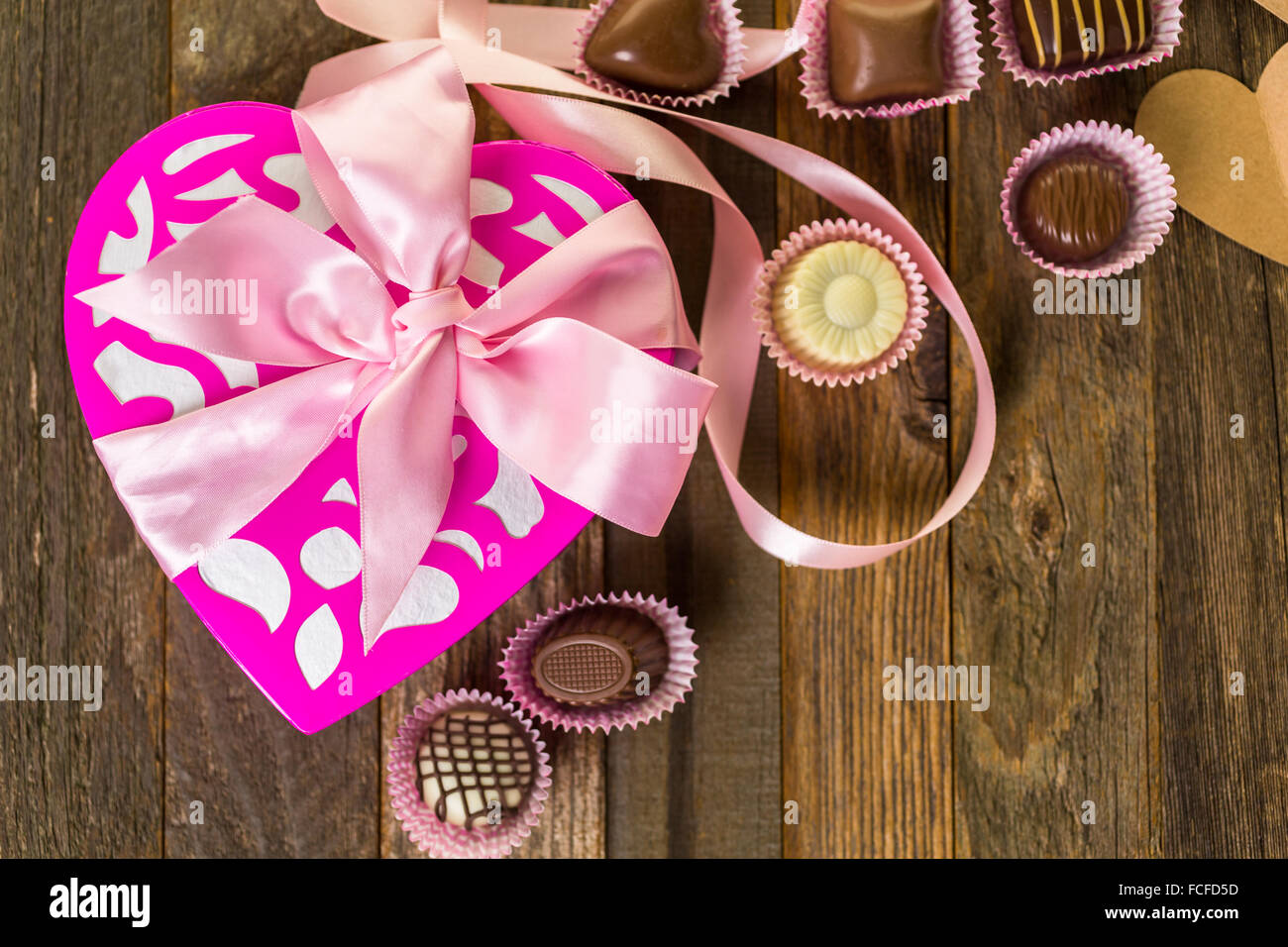 Chocolates in heart shaped box on rustic wood table Stock Photo - Alamy