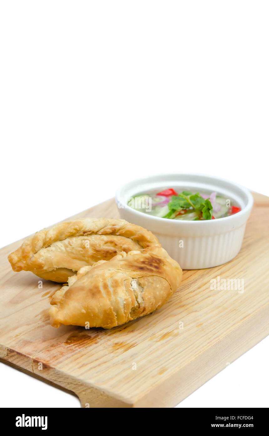 Curry puff pastry with sweet sauce on wooden plate Stock Photo - Alamy