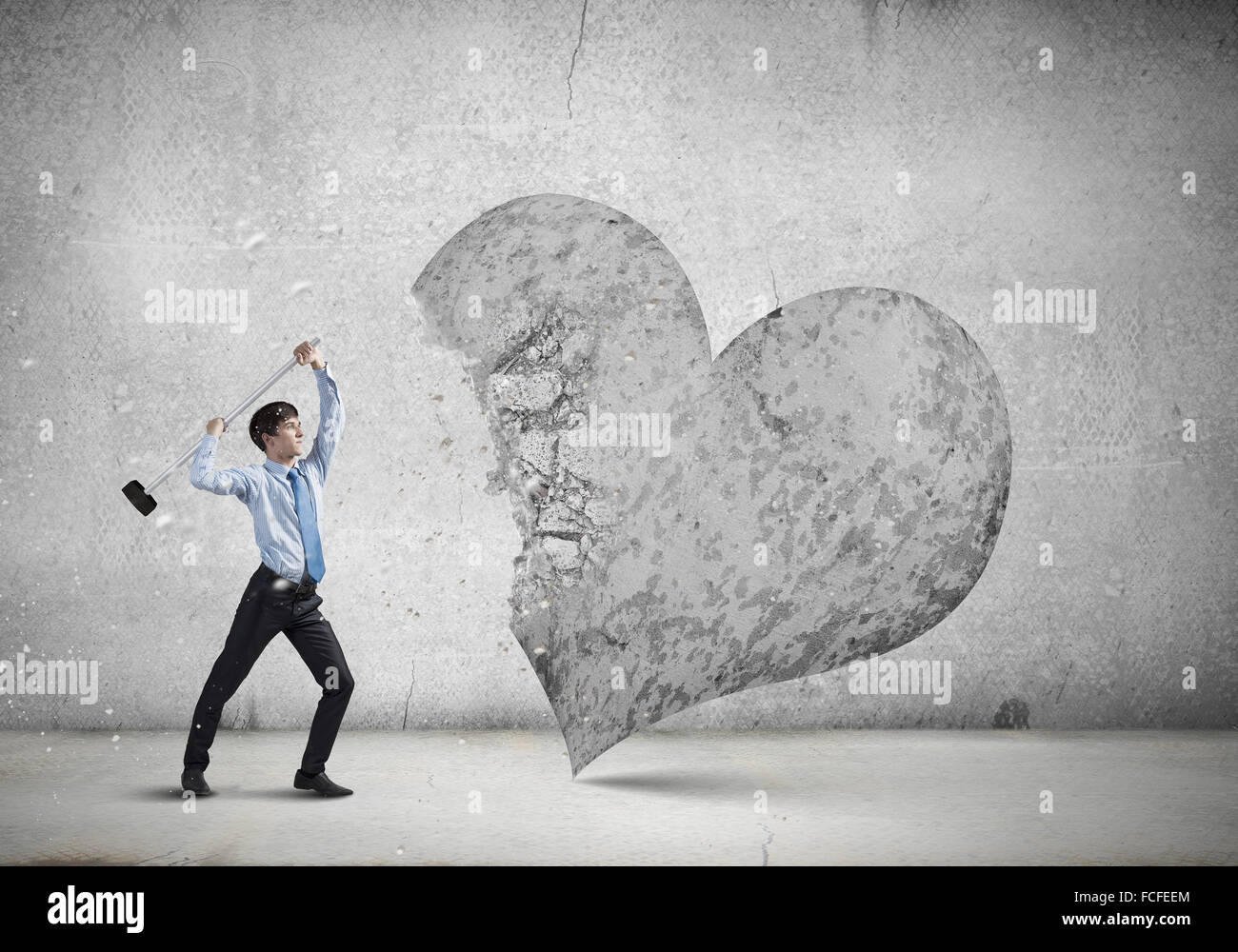 Young businessman breaking stone heart with hammer Stock Photo - Alamy