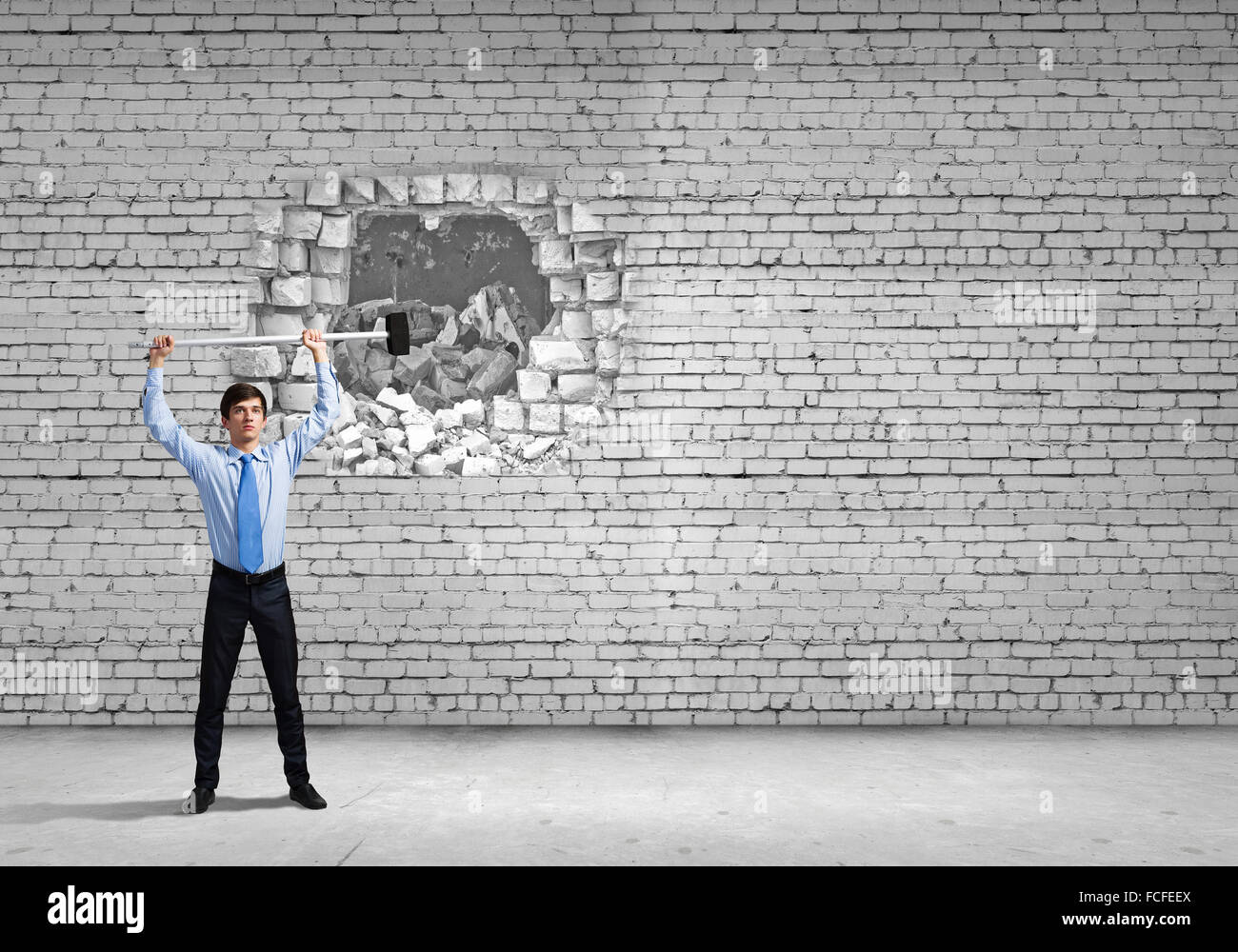 Young determined businessman breaking wall with hammer Stock Photo - Alamy