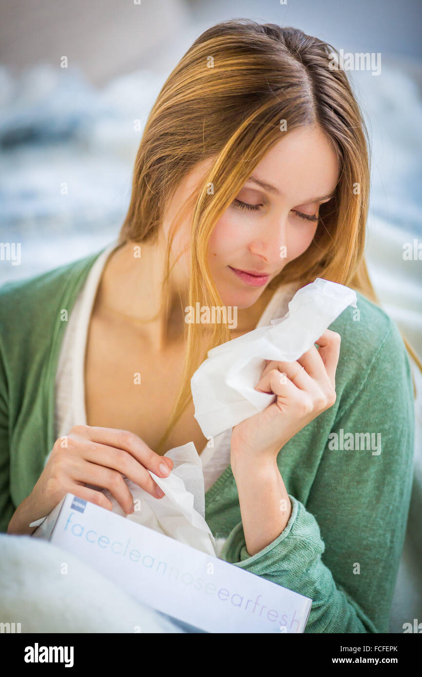 Woman with a cold using tissue Stock Photo - Alamy