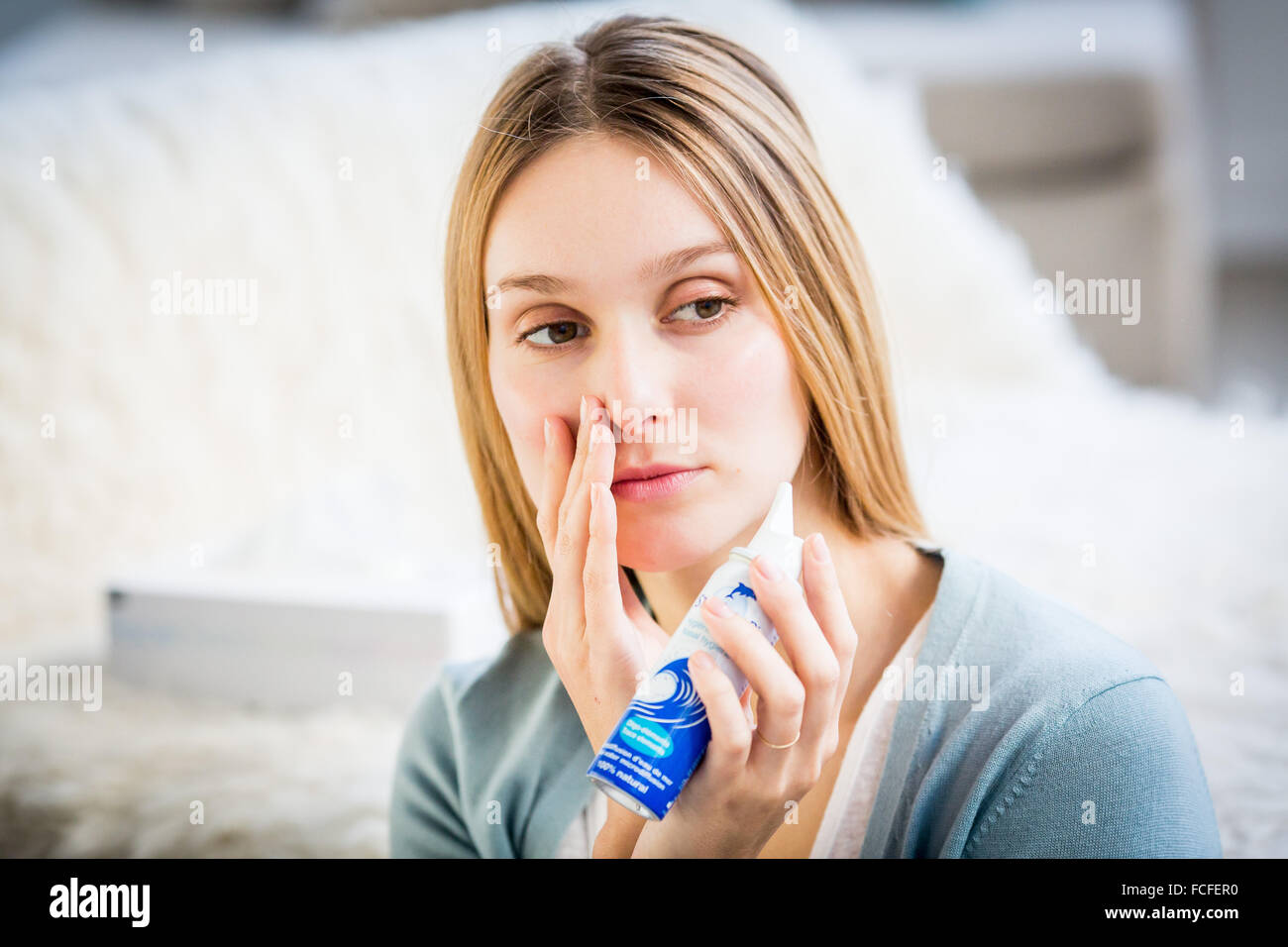 Woman using a sterile sea water spray Stock Photo - Alamy